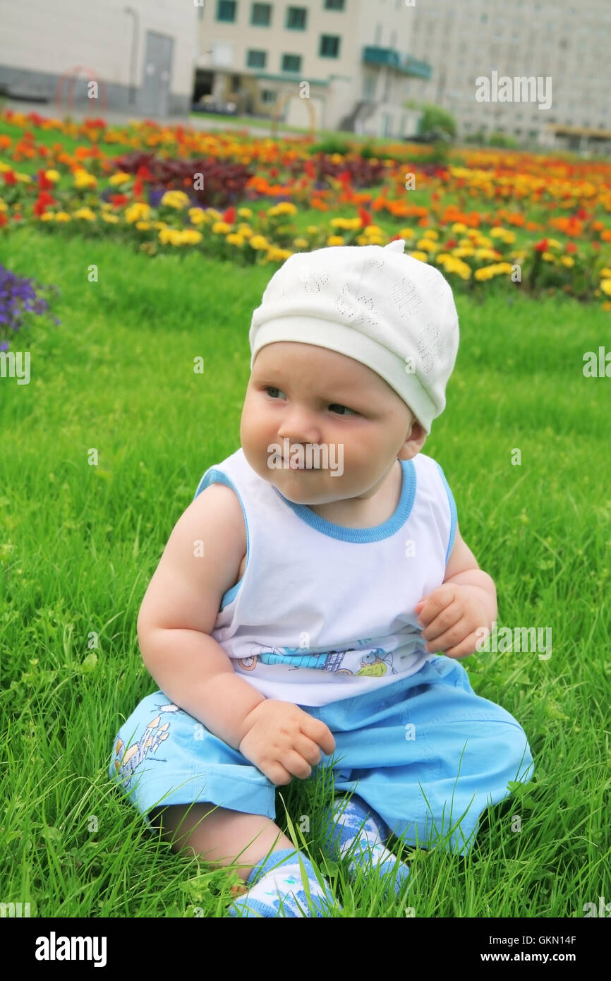 little boy with a happy kind sits on a grass Stock Photo - Alamy