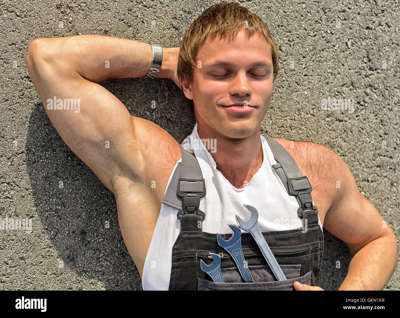 Tired mechanic resting on the road Stock Photo - Alamy