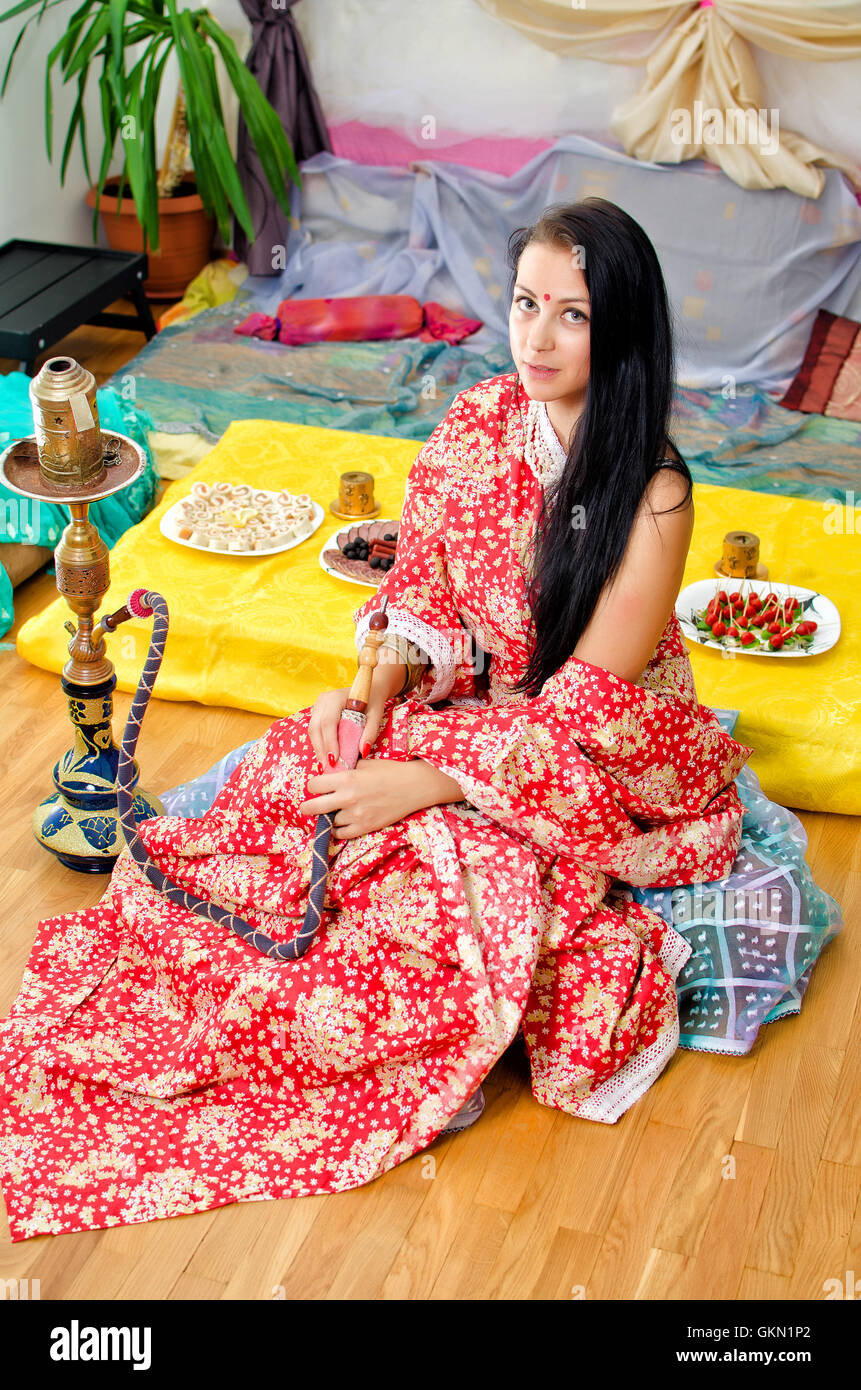 Young Indian girl in traditional red clothing with Hookah Stock Photo ...
