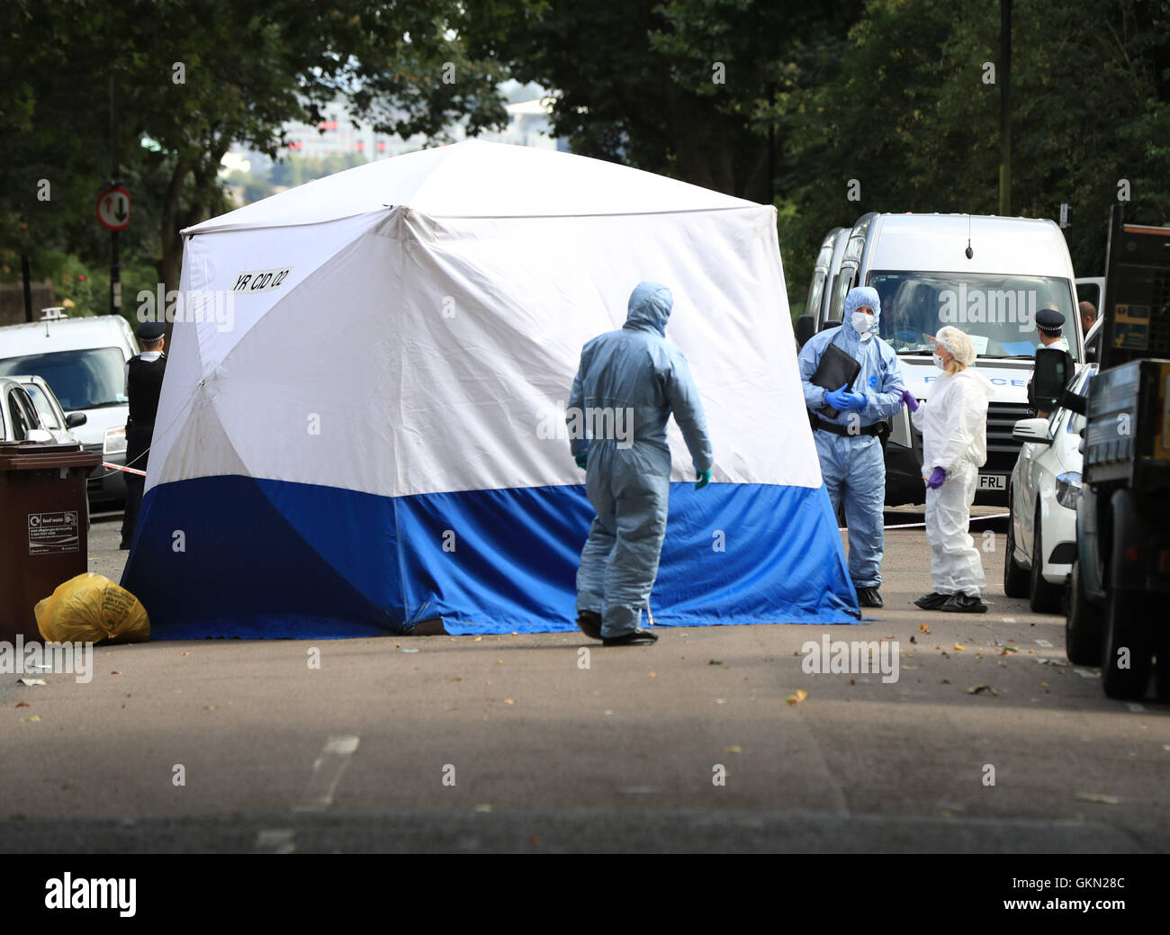 Forensics officers by a police tent in the middle of Sunnyside Road ...
