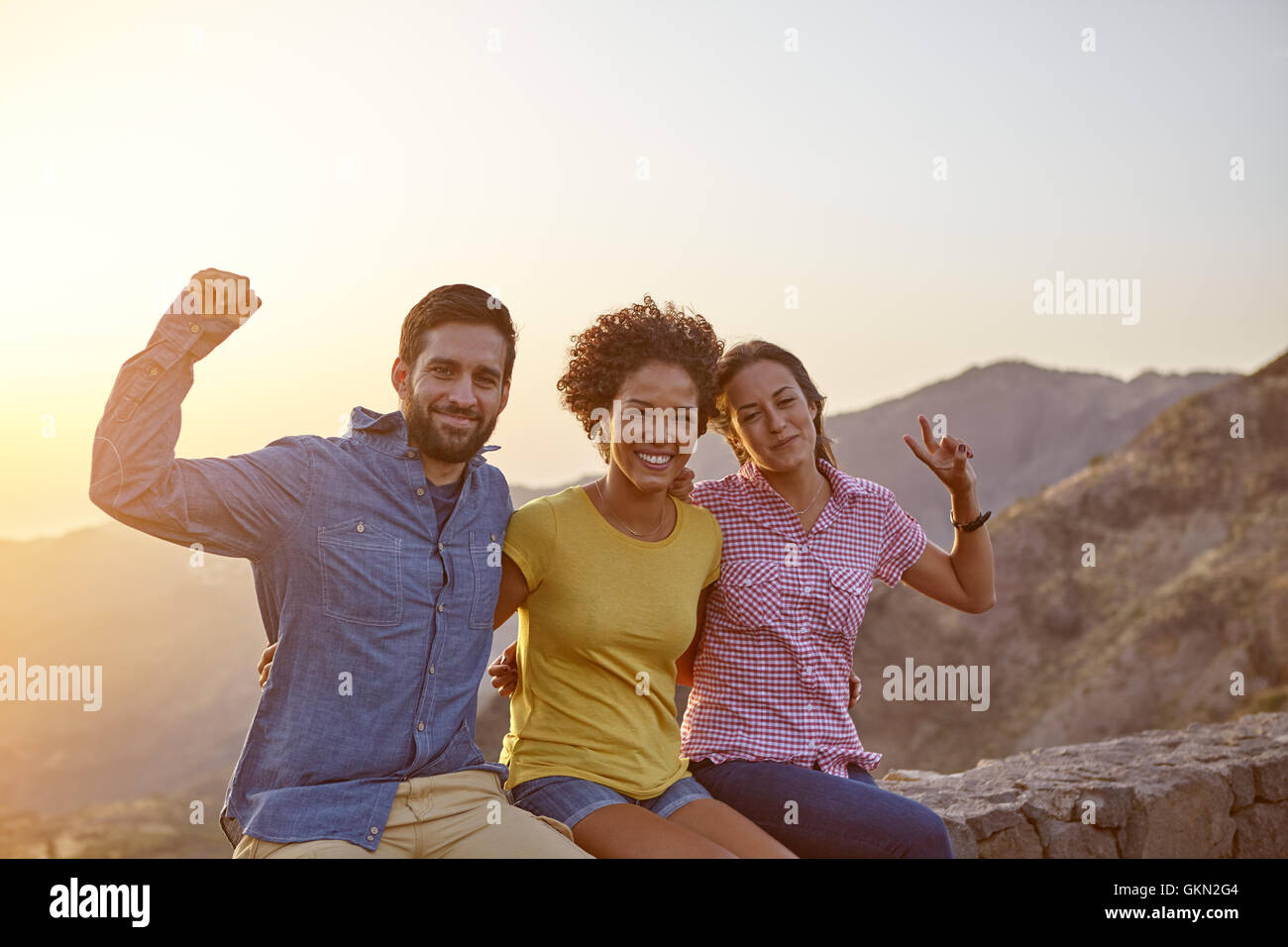 Three celebrating friends posing for a picture in the late afternoon ...
