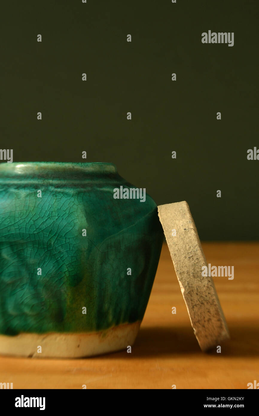Ceramic ginger pot sitting on light wood table Stock Photo - Alamy