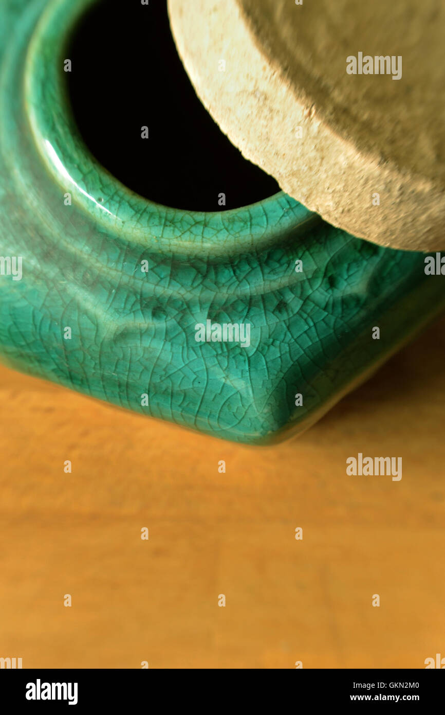 Ceramic ginger pot sitting on light wood table Stock Photo - Alamy