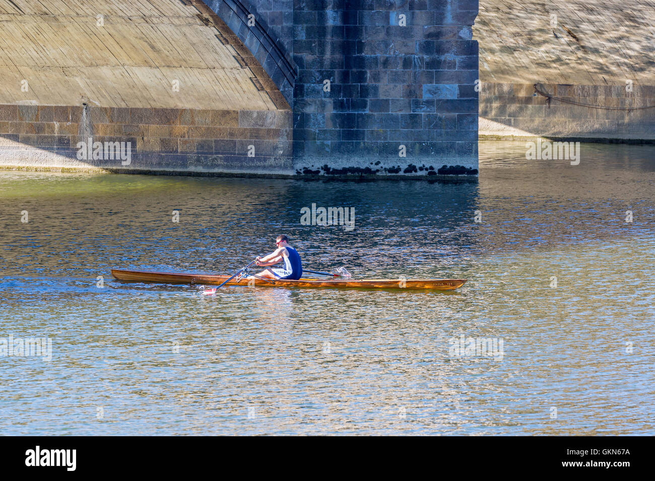 Man rowing a sculling boat under a bridge Stock Photo - Alamy
