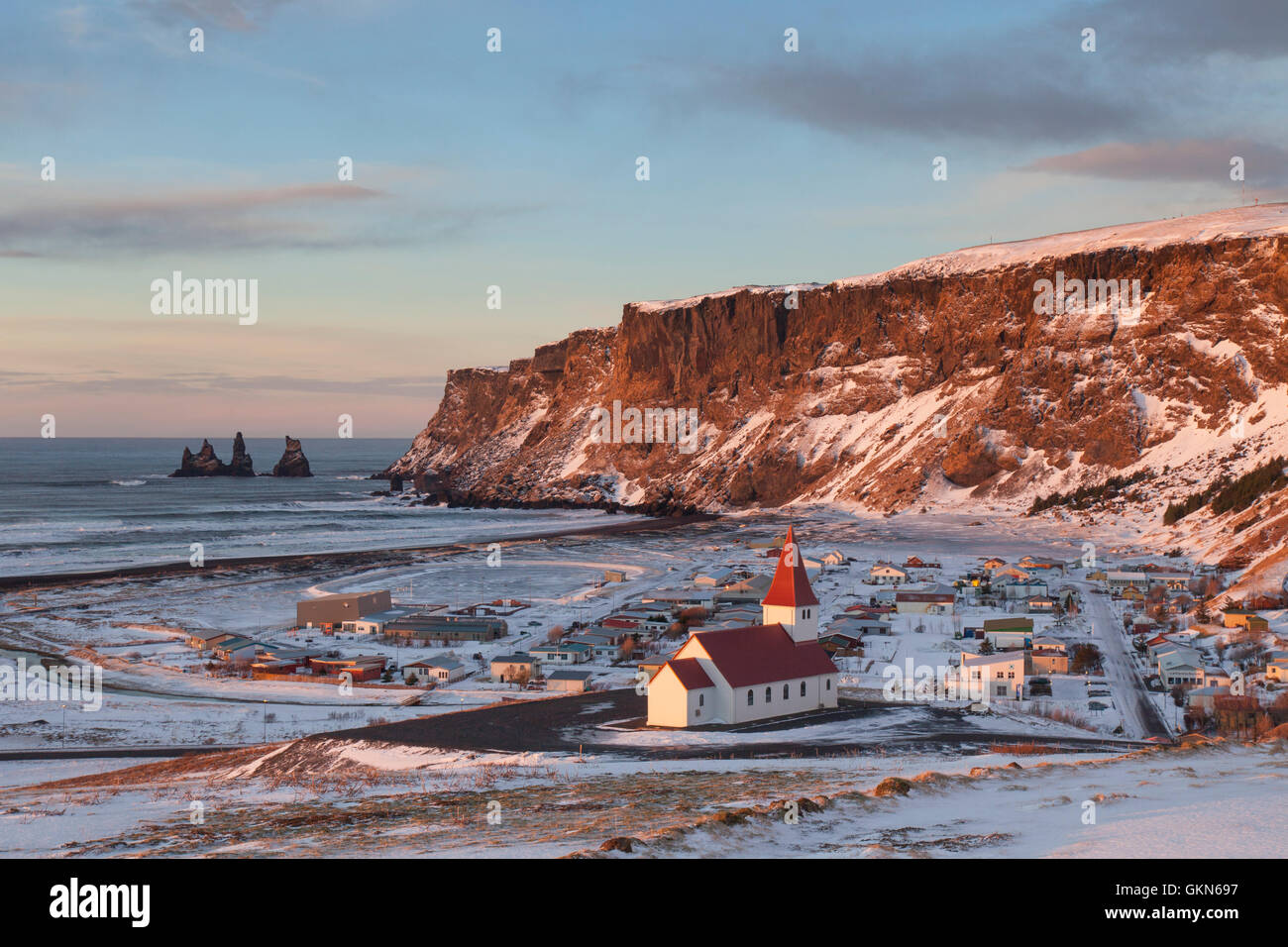 Reynisdrangar sea stacks and the Vík church at the village Vík í Mýrdal ...