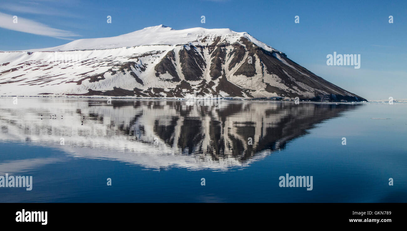 Svalbard mountains reflected in still blue arctic sea Stock Photo - Alamy