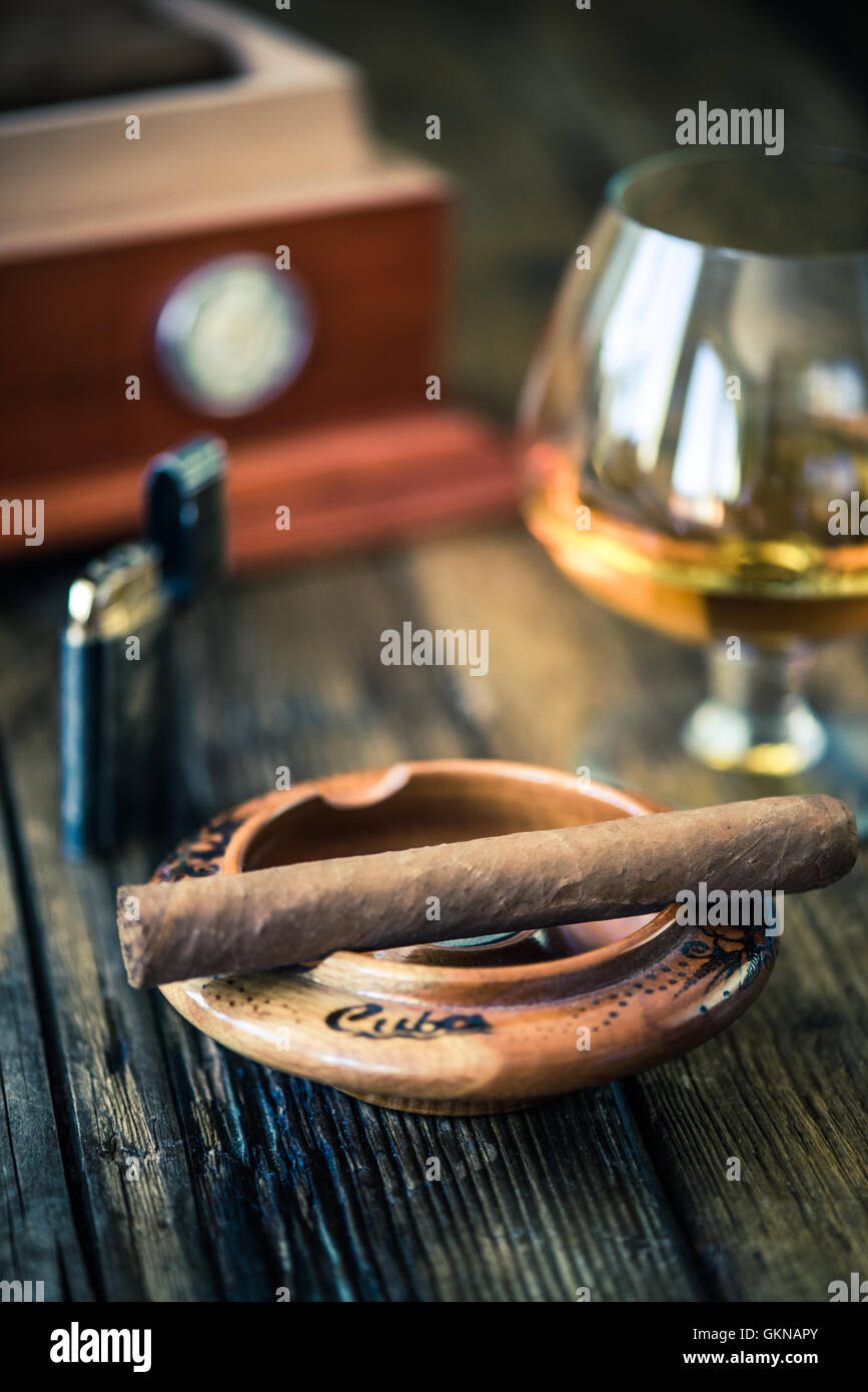 Cuban cigar in wooden traditional ash tray on table Stock Photo - Alamy