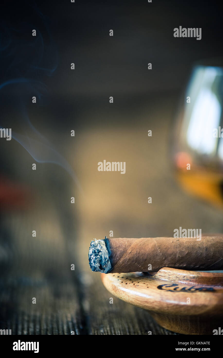 smoking cigar close up view, in wooden ashtray Stock Photo - Alamy