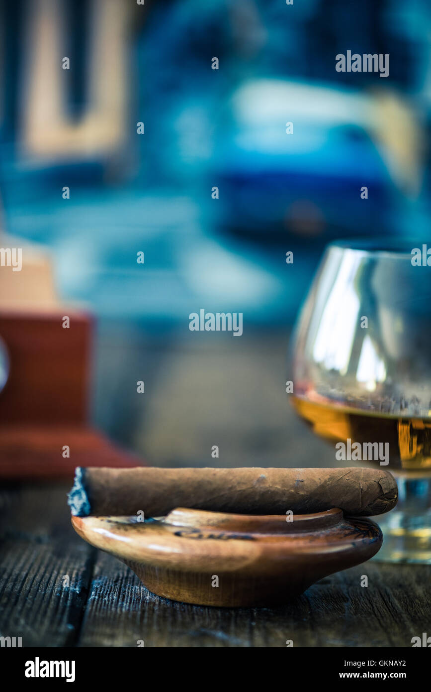 cuban cigar and glass of rum or cognac on wooden table with cuban ...