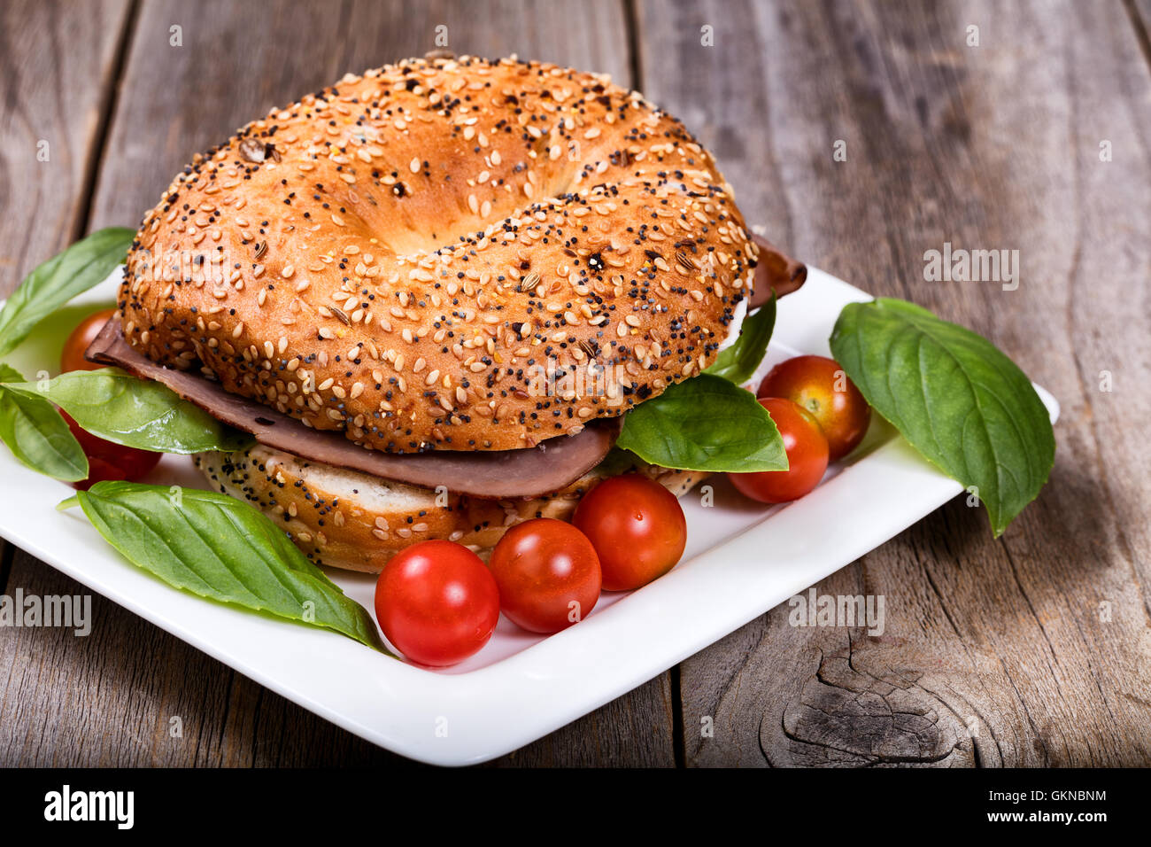 Close up front view of a fresh sandwich with seeded bun, cherry ...