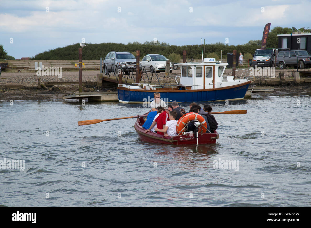 Man using rowing boat ferries Families across the River Blythe in ...
