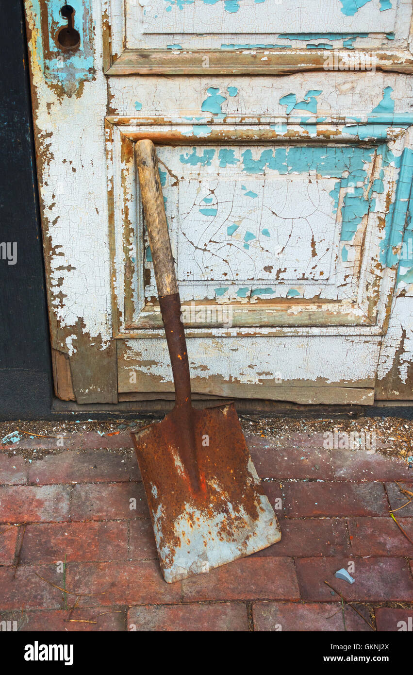 Old rusted shovel leaning against an old door Stock Photo - Alamy