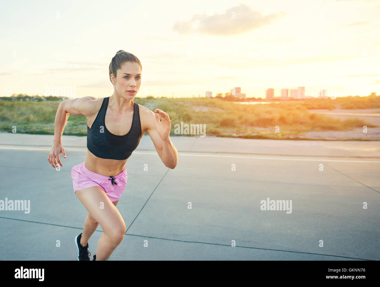 Fit competitive female sprinter working out practising her running ...