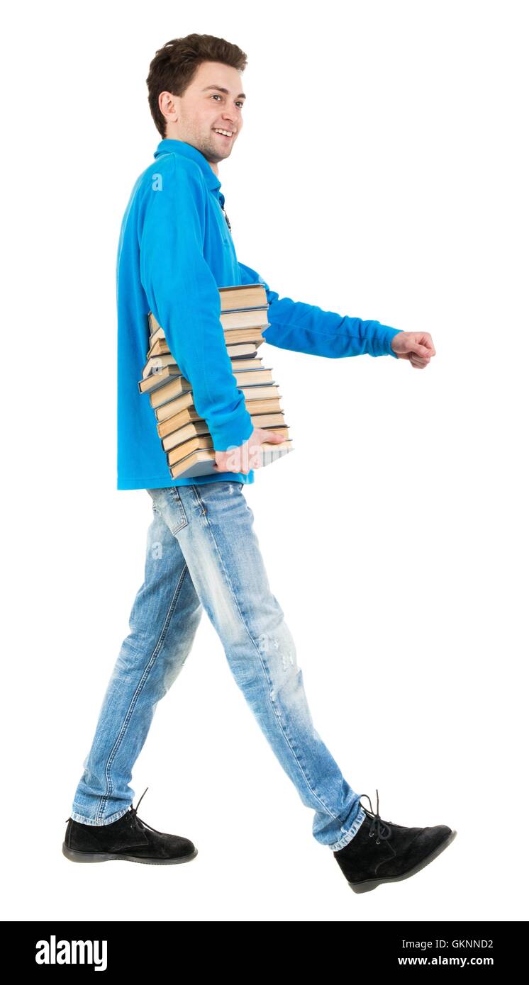 Back view of going handsome man carries a stack of books Stock Photo ...
