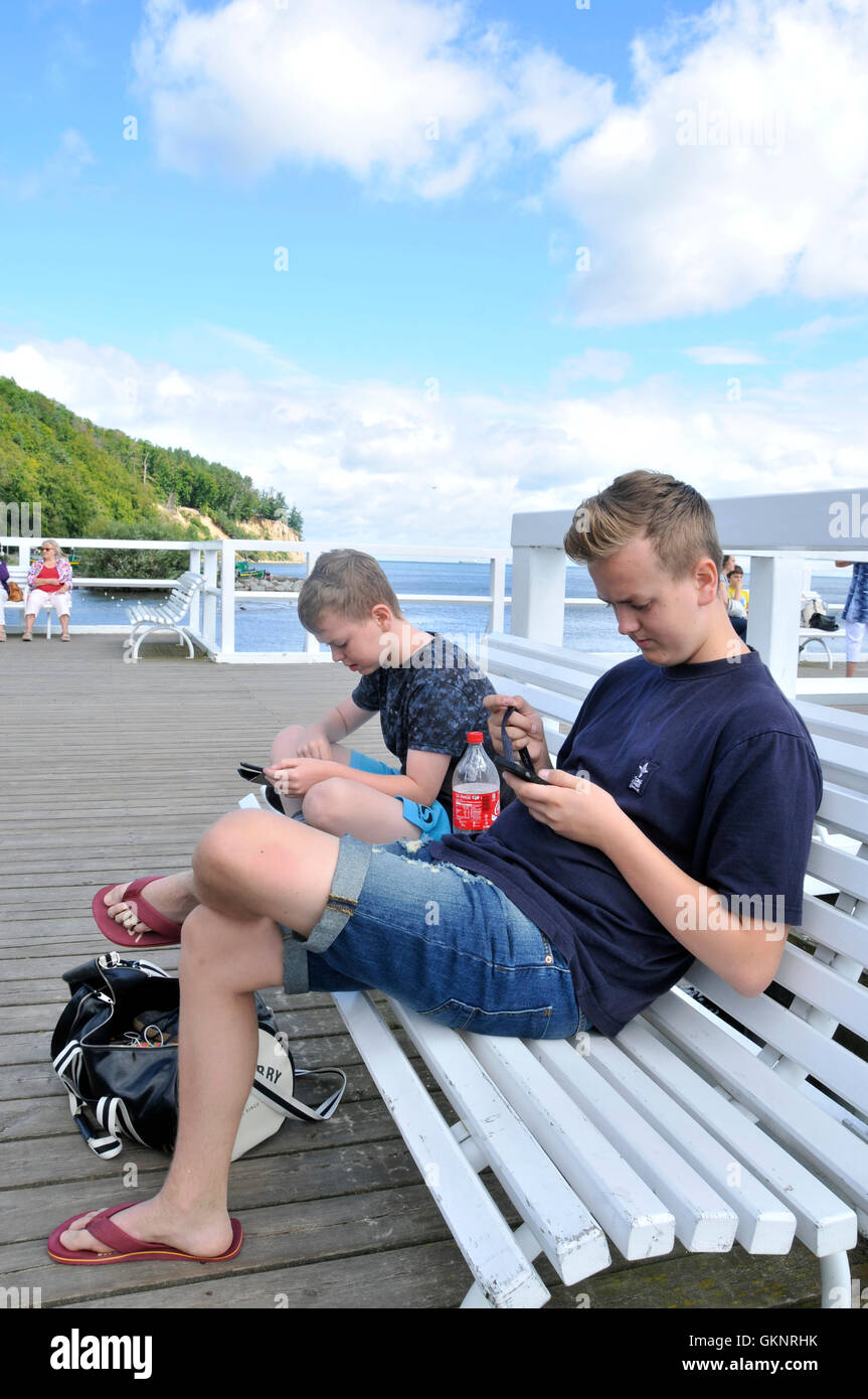 Boys on holiday vacation playing on phones Stock Photo - Alamy