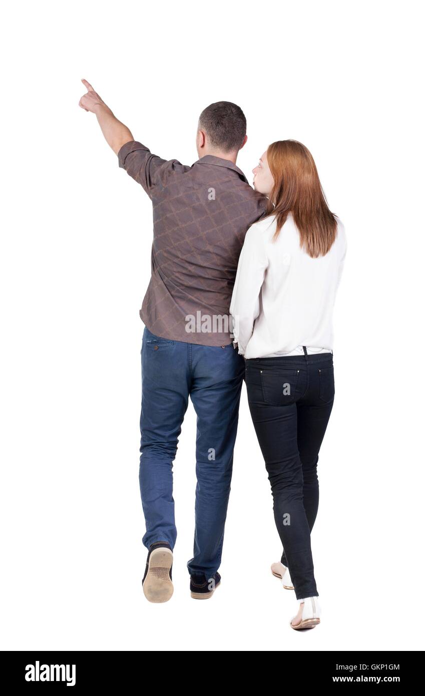 Back view of walking young couple man and woman pointing Stock Photo ...