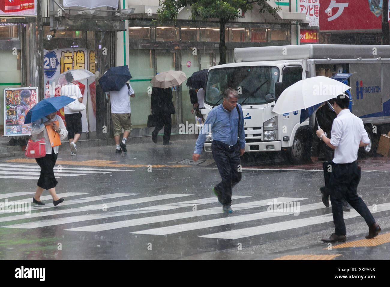 Tokyo, Japan 22nd Aug, 2016 Pedestrians hold umbrellas under the rain ...