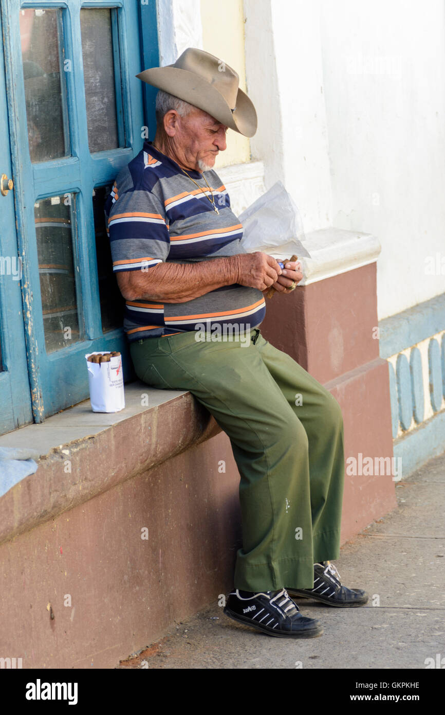 A Cuban man sits on a window ledge selling cigars in Trinidad, Sancti ...