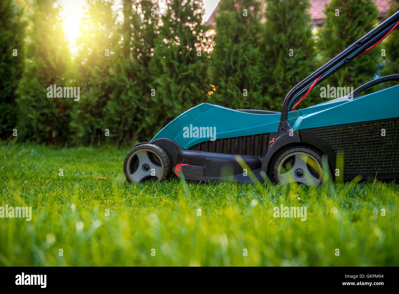 lawn mower in the garden at sunset Stock Photo - Alamy