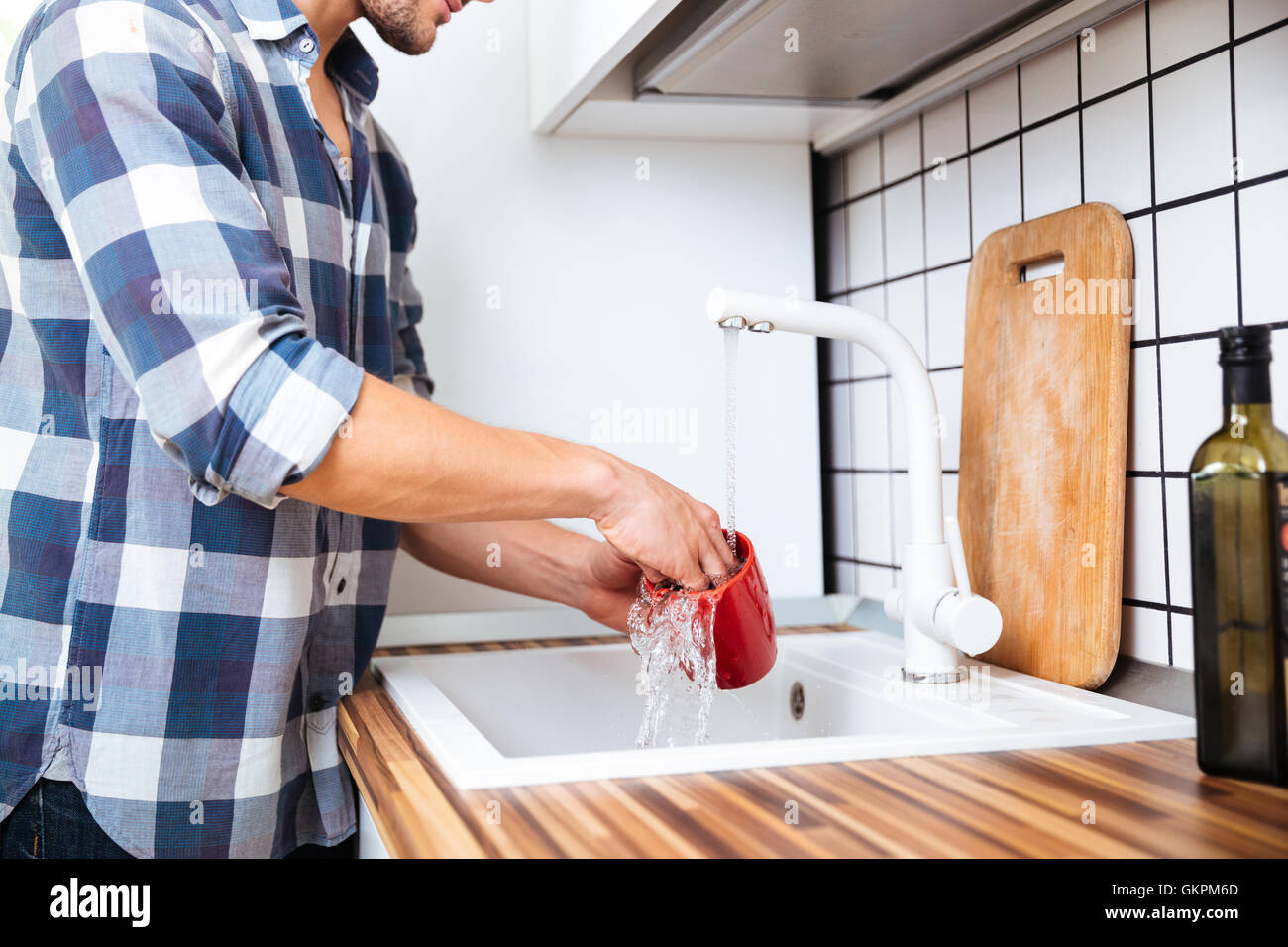 House husband washing dishes in the kitchen sink hi-res stock ...