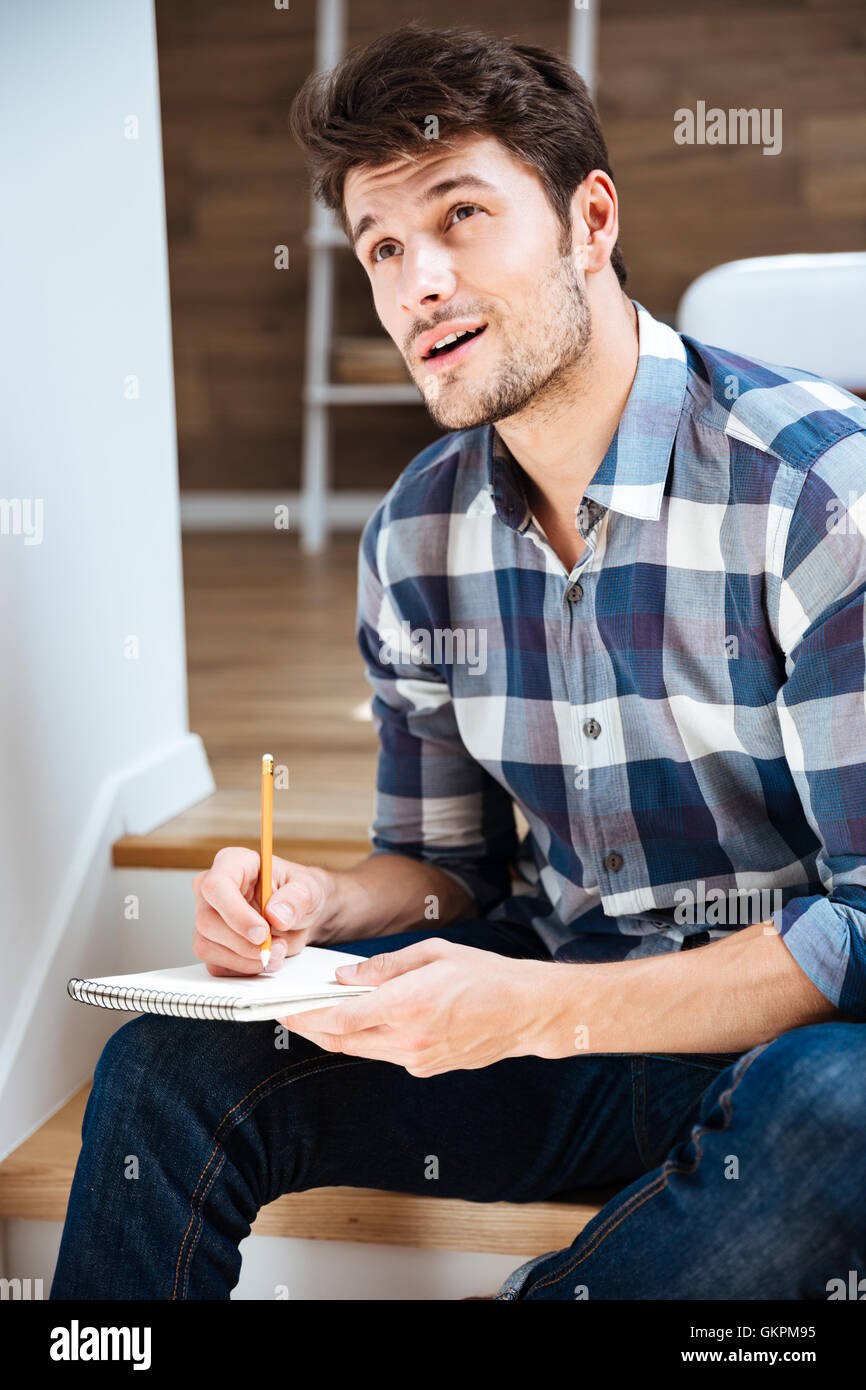 Pensive man writing notes in hi-res stock photography and images - Alamy