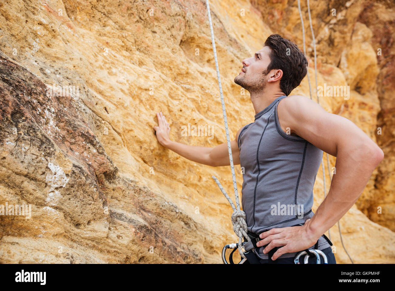 Young handsome sportsman getting ready to climb up a rock cliff Stock ...