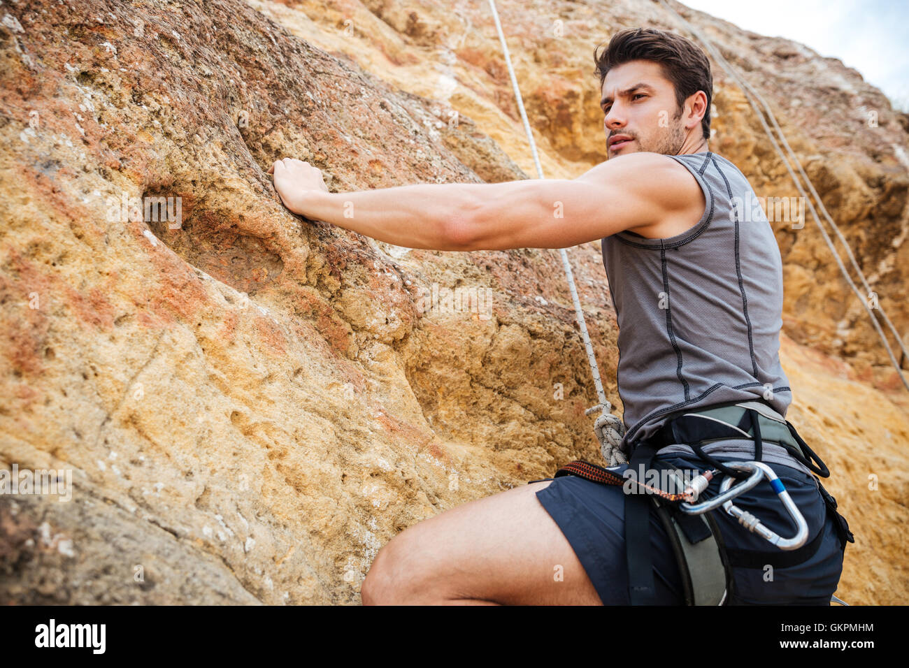 Young fearless man climbing a steep wall in mountain Stock Photo - Alamy