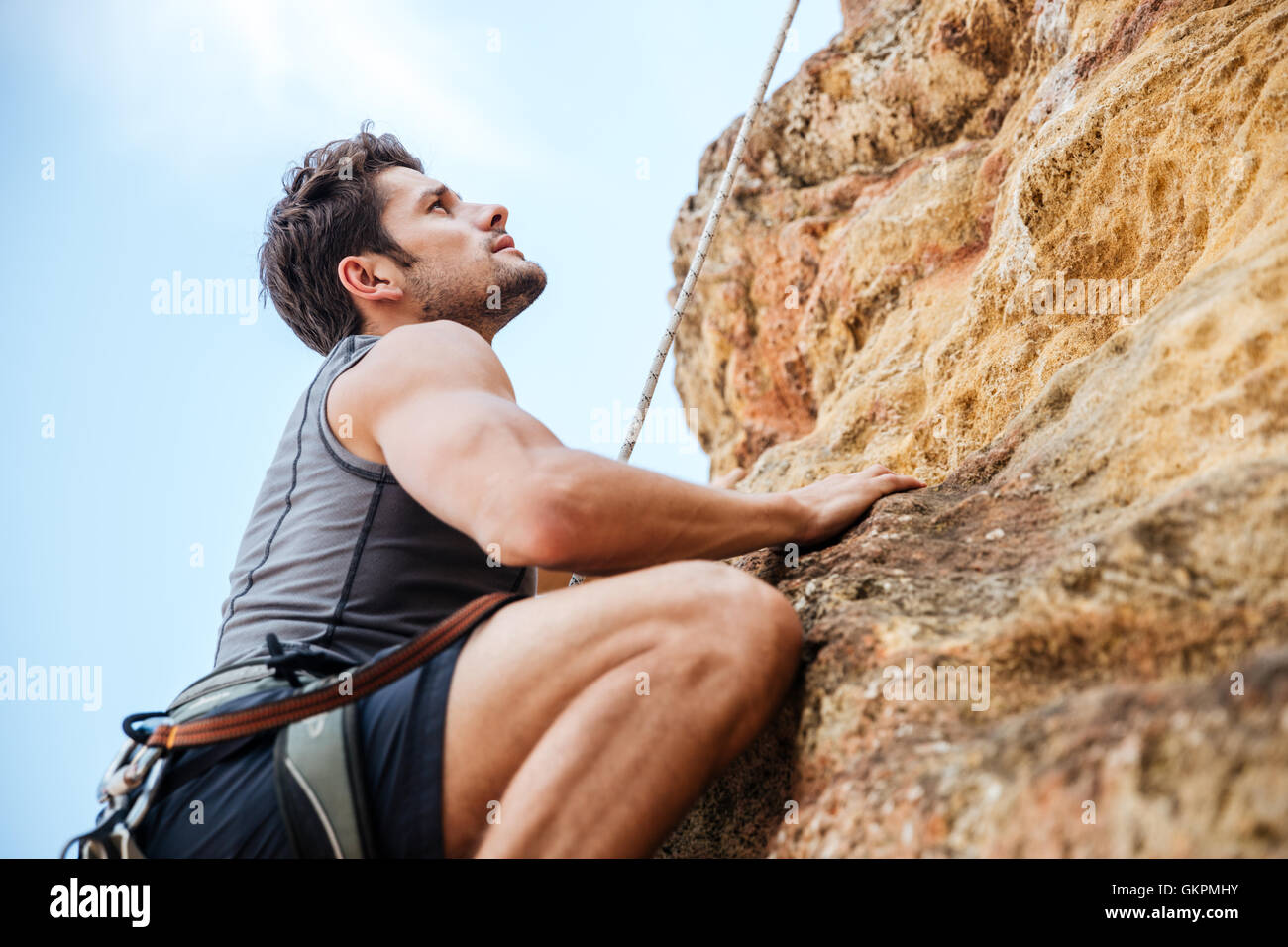 Young fearless man climbing a steep wall in mountain Stock Photo - Alamy
