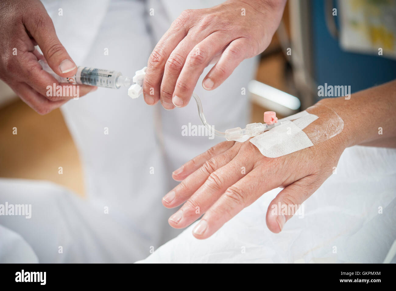 Verpleegkundigen sluiten een infuus aan bij de patient. De ...