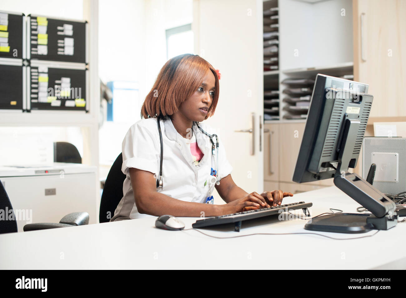Nurse working behind nurses counter Stock Photo - Alamy