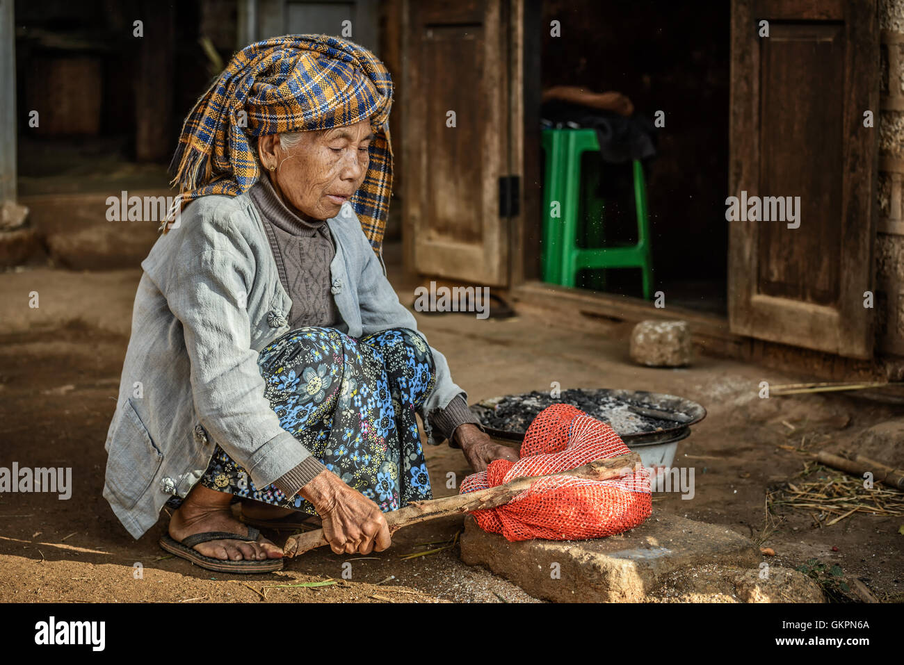 Old woman working in front of her home Stock Photo - Alamy