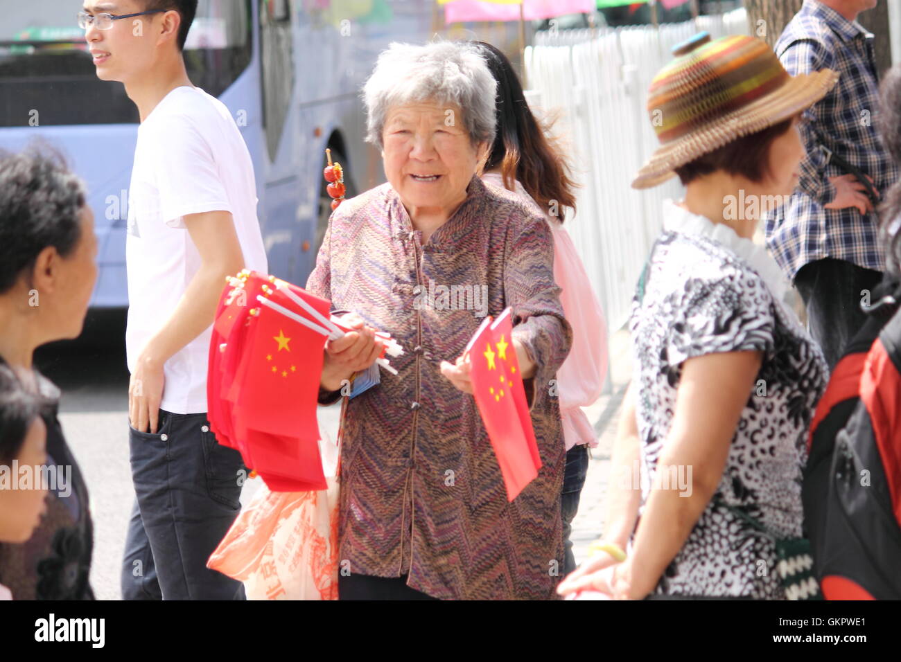 Lady sells souvenirs to tourists in front of Qien Men in Beijing China ...