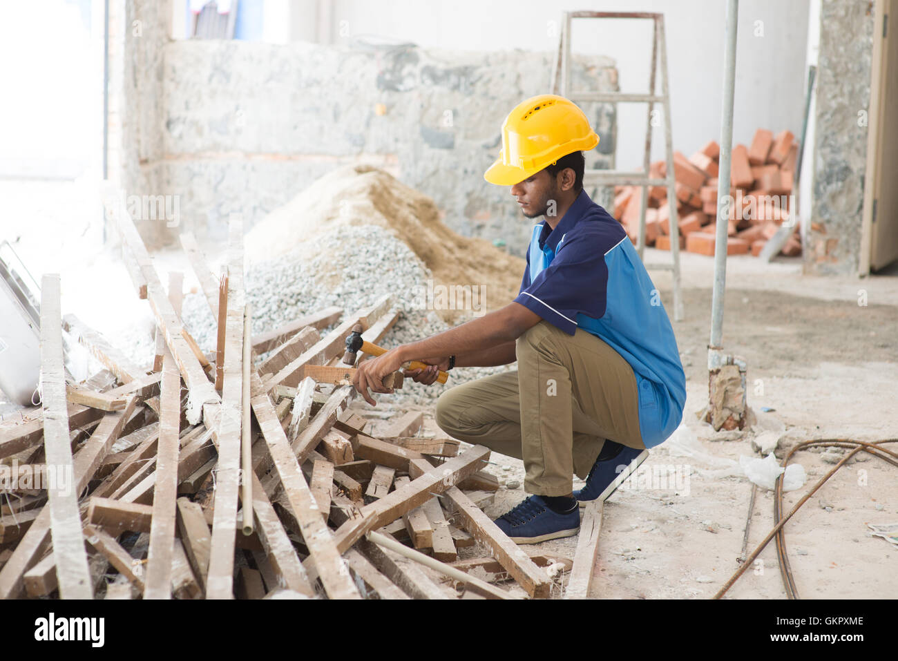 indian male contractor on site using hammer Stock Photo - Alamy