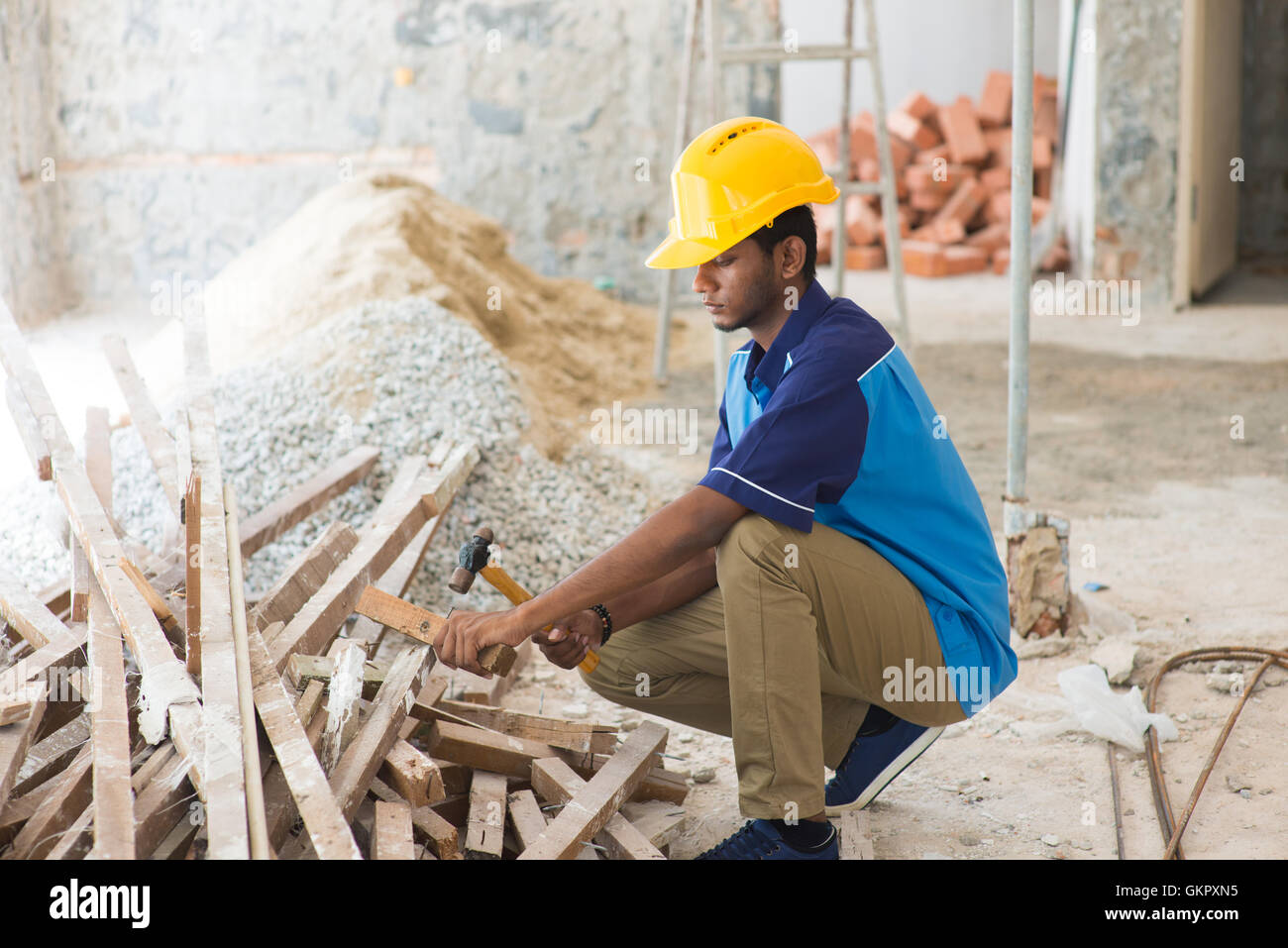 indian male contractor on site using hammer Stock Photo - Alamy