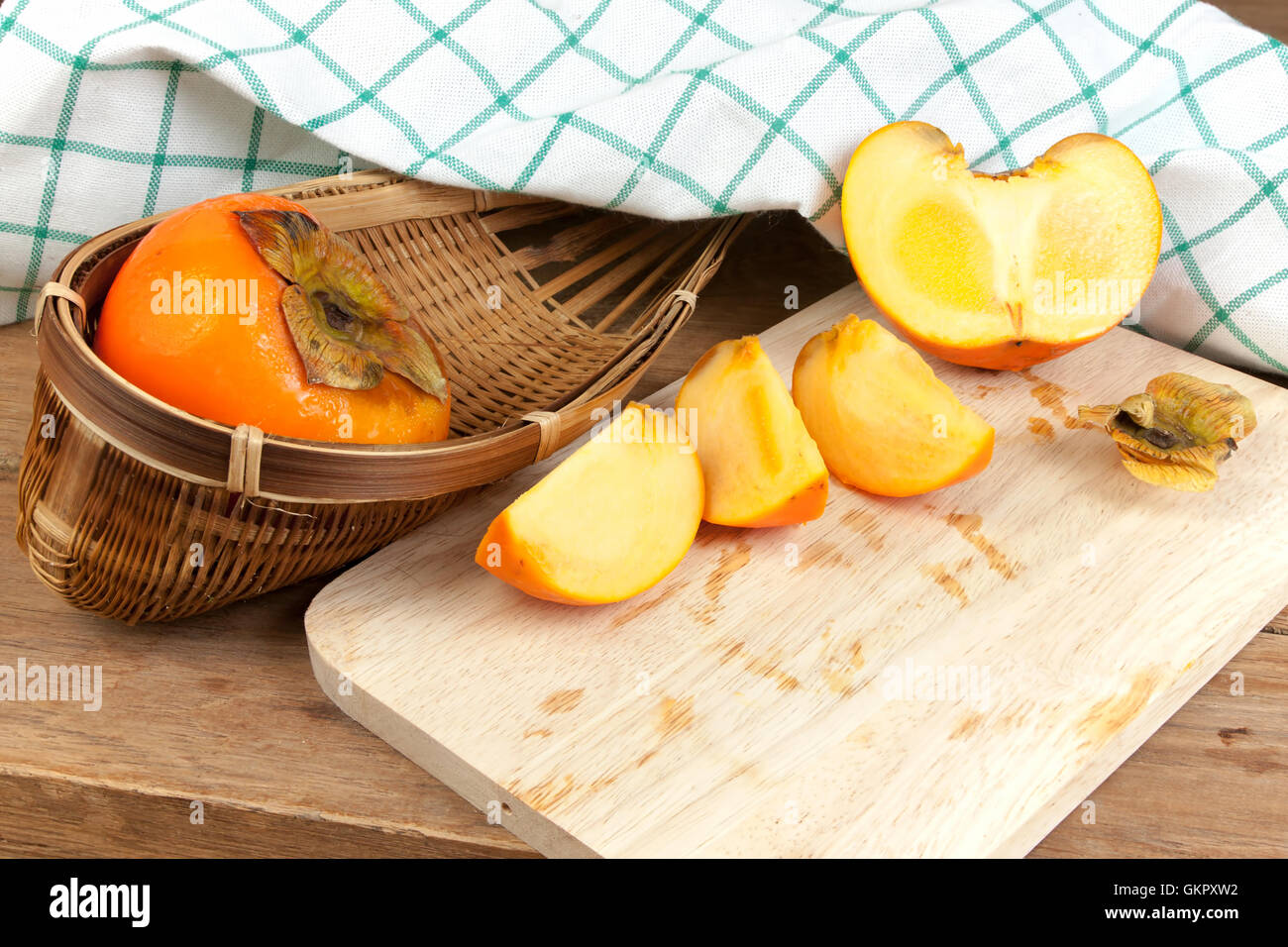 Persimmon yellow color ripe split fruits on wood table Stock Photo - Alamy