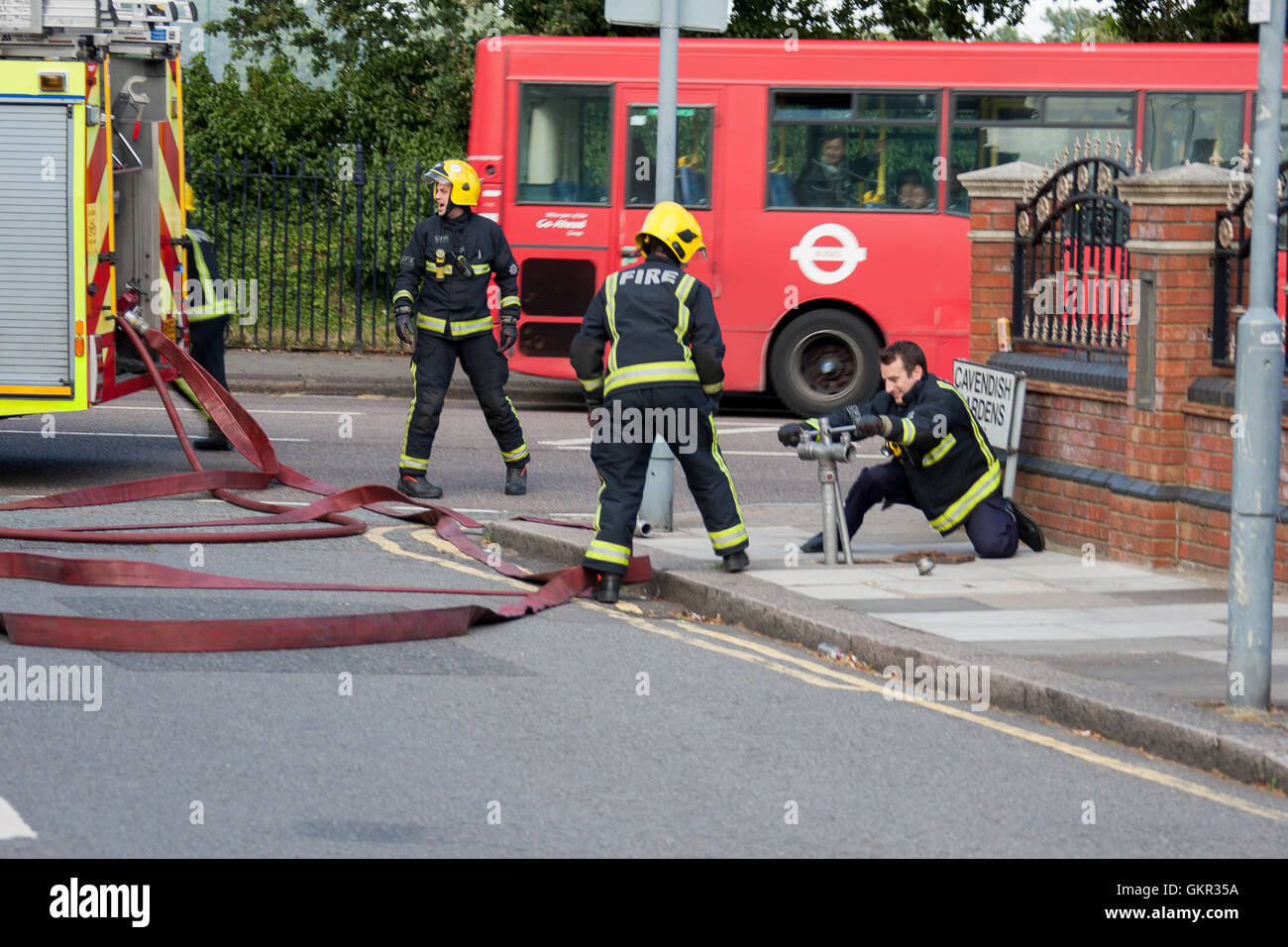 Firefighters setting up a water supply from a hydrant during a fire at ...