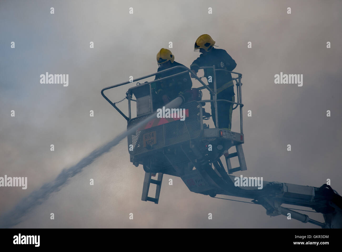 Two London firefighters and smoke whilst operating a height platform at ...