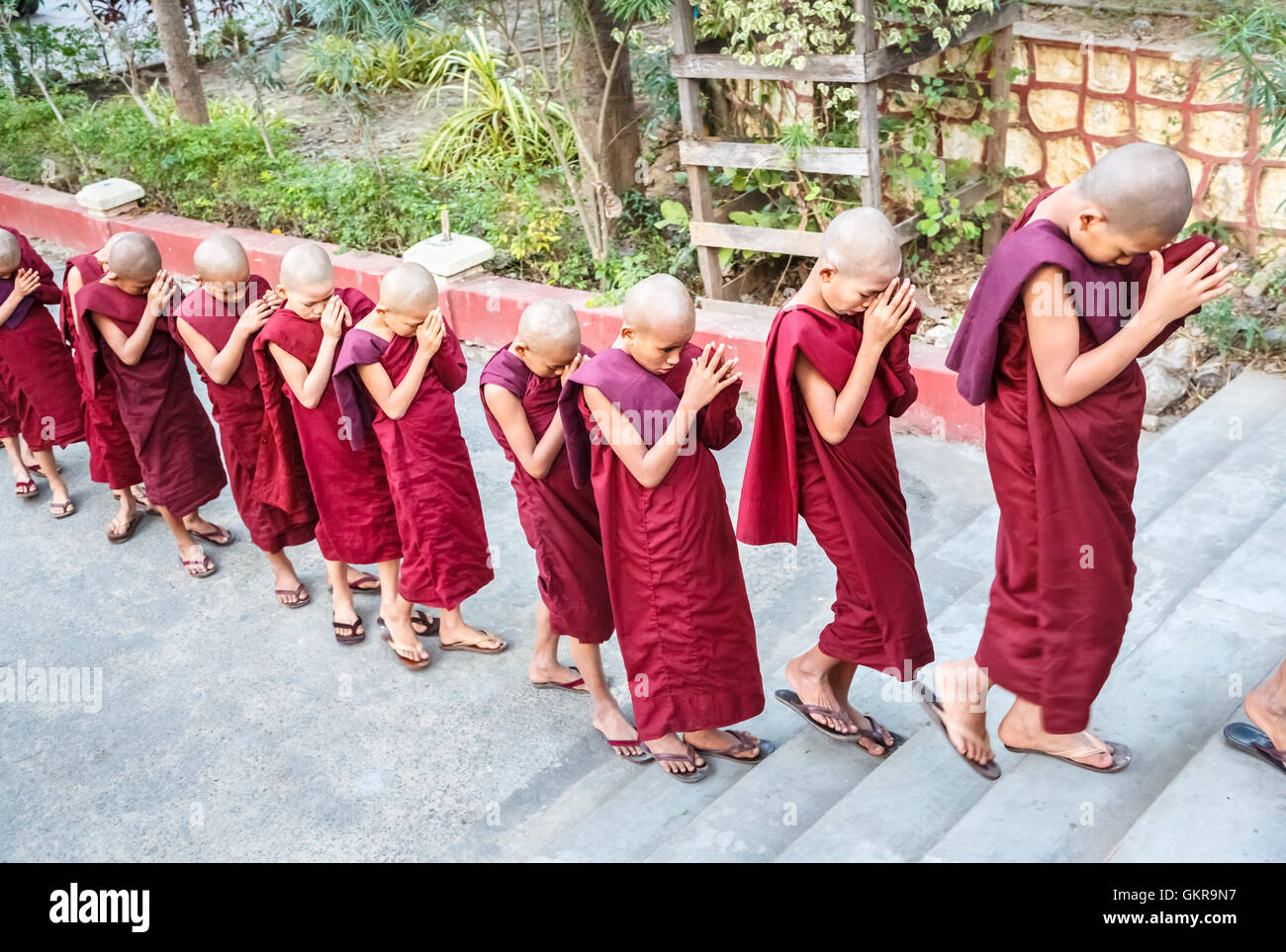 Buddhist novice monks at an evening prayer ceremony entering Shwe Kyin ...
