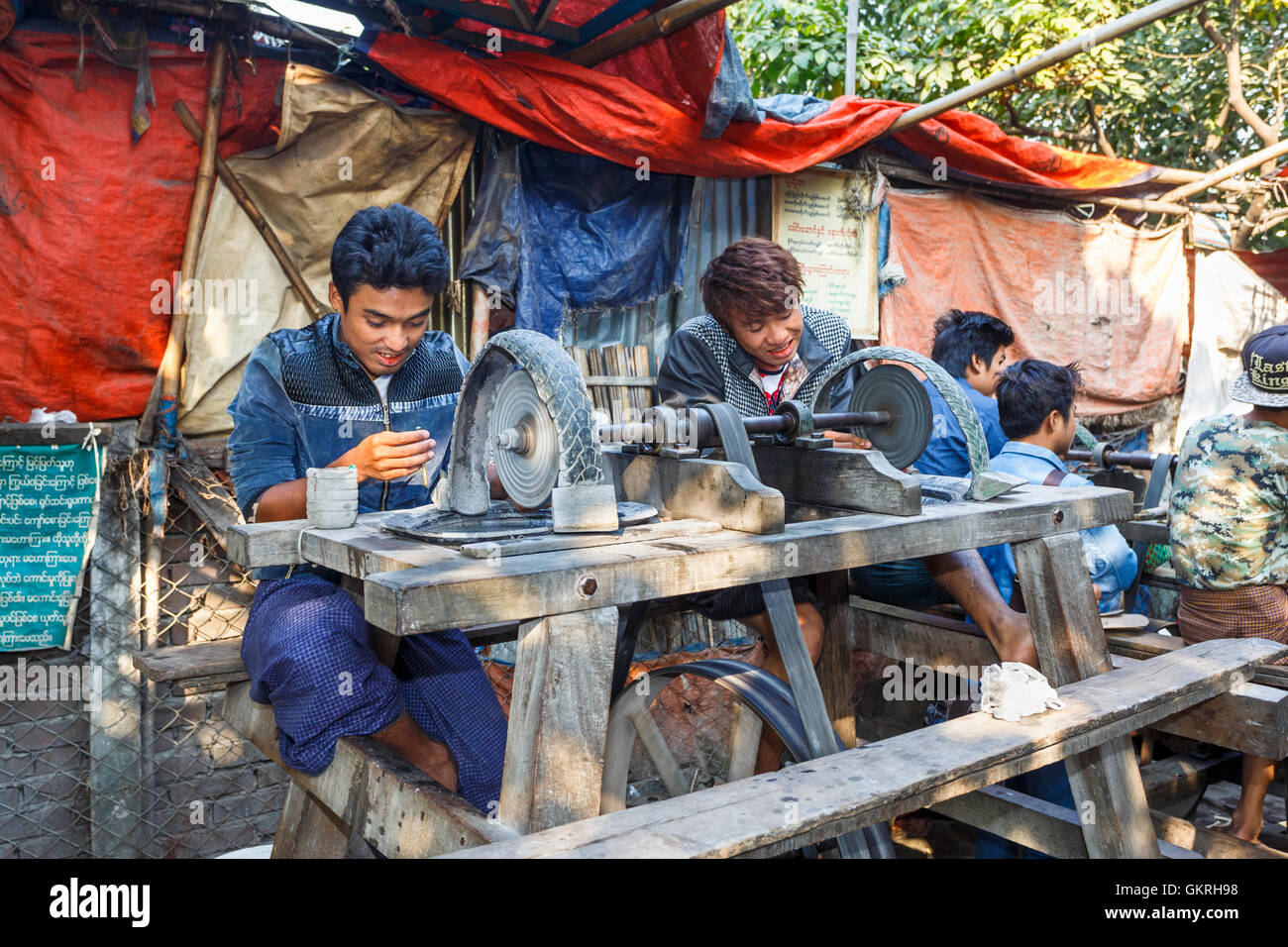 Young local men working, grinding and polishing jade by traditional ...