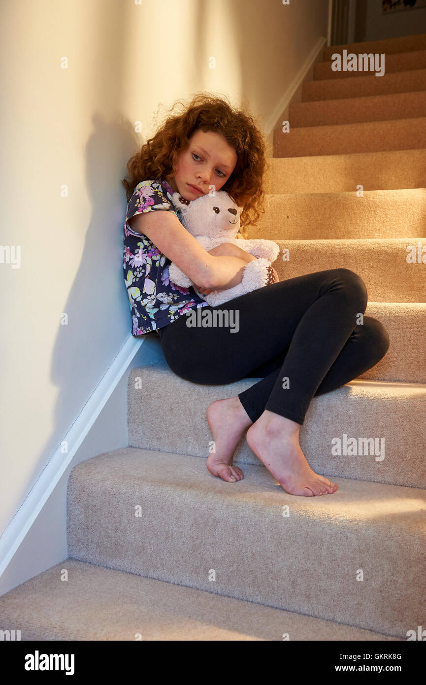 Child abused and upset sitting on the stairs alone Stock Photo - Alamy