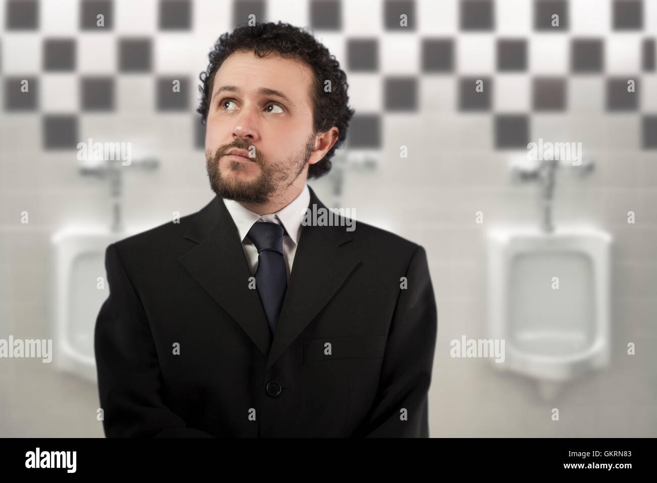 businessman with a distracted look urinating in urinals Stock Photo - Alamy