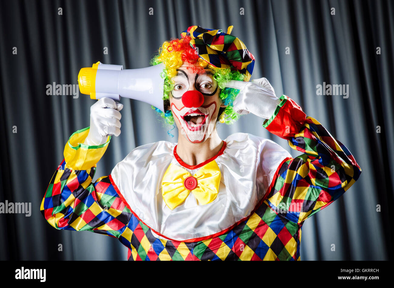 Clown in studio with loudspeaker Stock Photo - Alamy