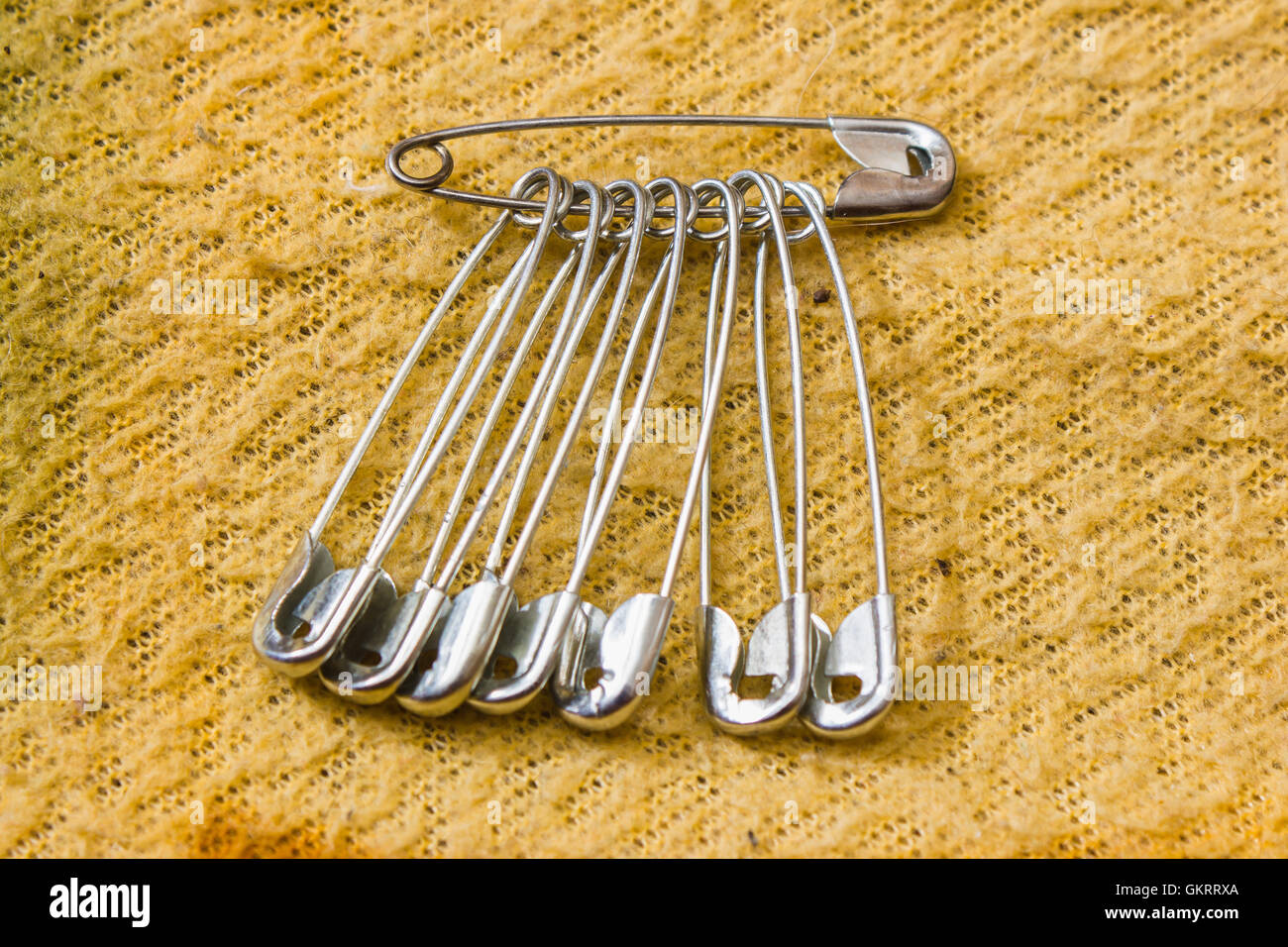 Safety pin pinned to the texture fabric Stock Photo - Alamy