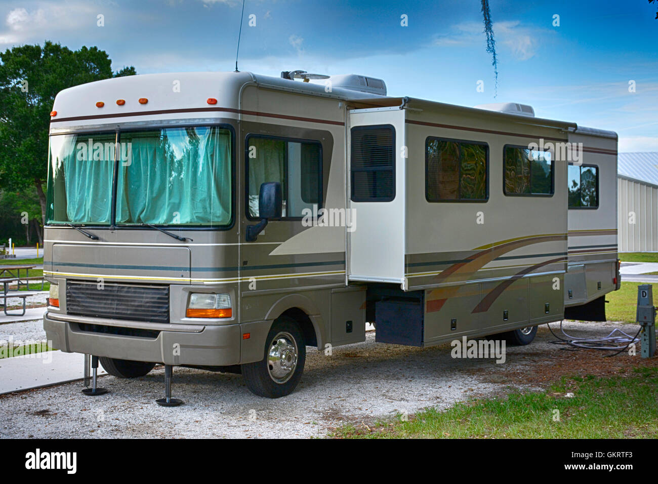 Front and side view of a 32ft class A motorhome with slideouts at a ...