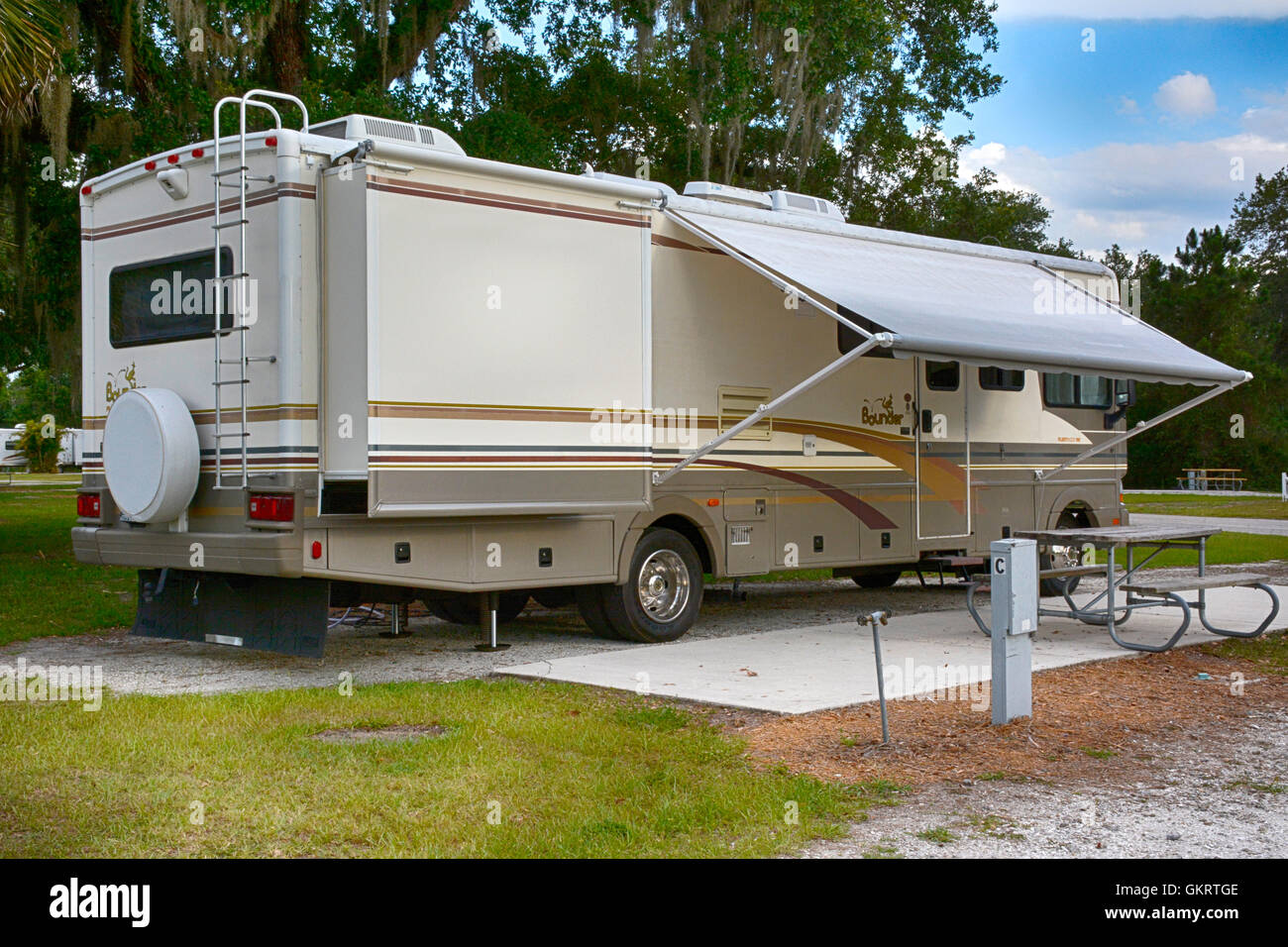Bedroom slideout side view of a 32ft class A motorhome set up at a park ...