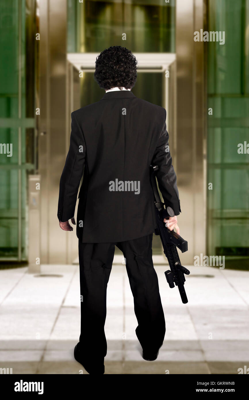 man entering a business building with a machine gun Stock Photo - Alamy