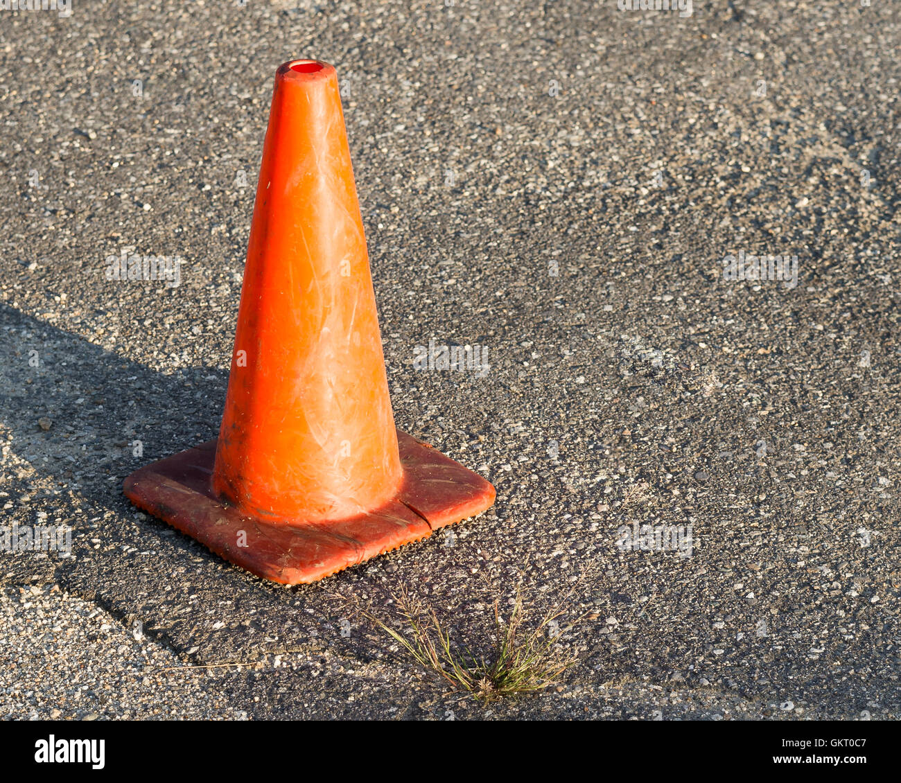 Parking cone in rough shape on rough patch of pavement Stock Photo - Alamy