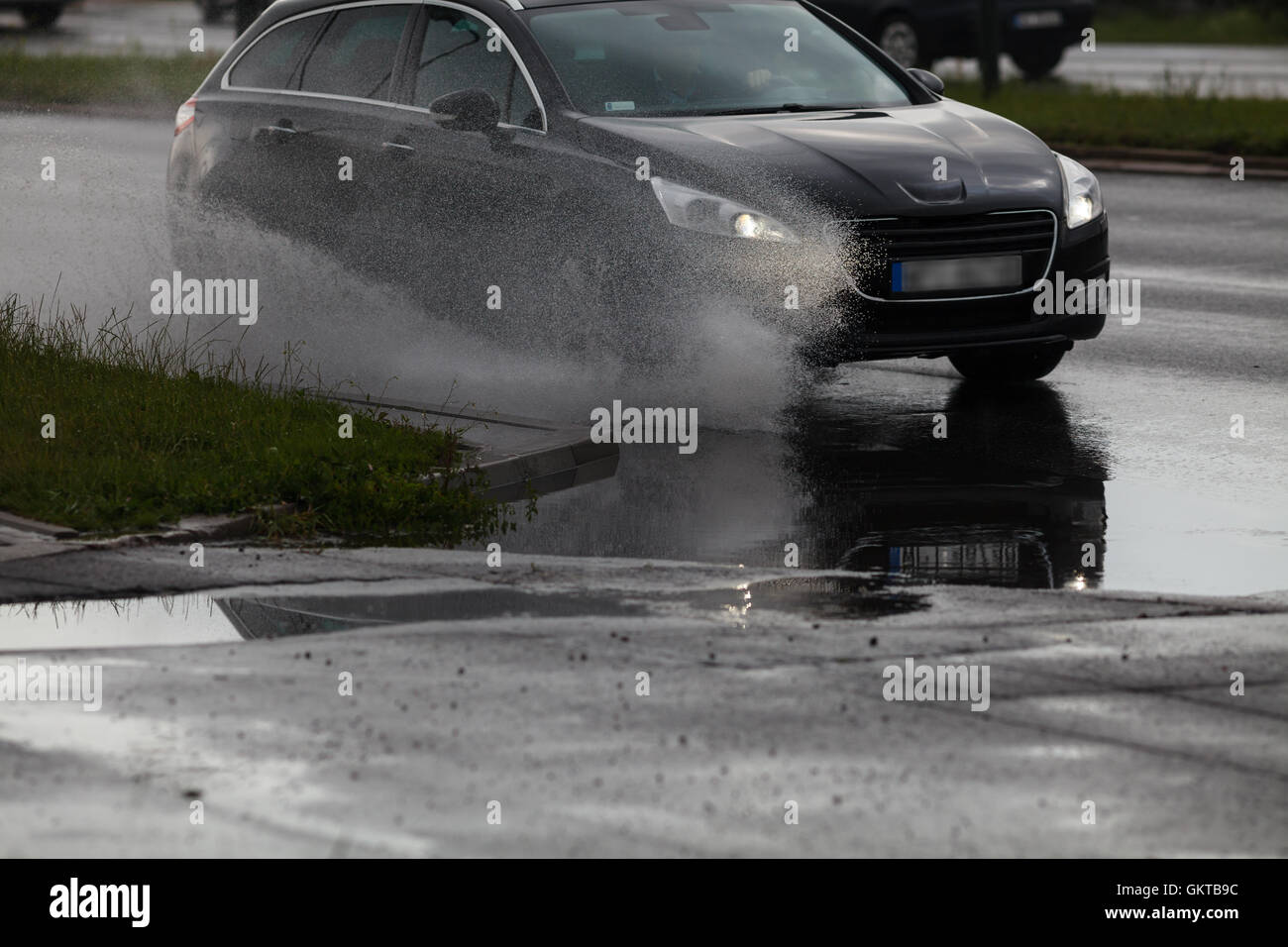 Car splashing water on the street after rain Stock Photo - Alamy