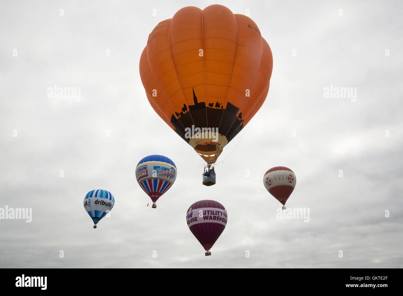 A group of five hot air balloons make the final descent to land at the ...