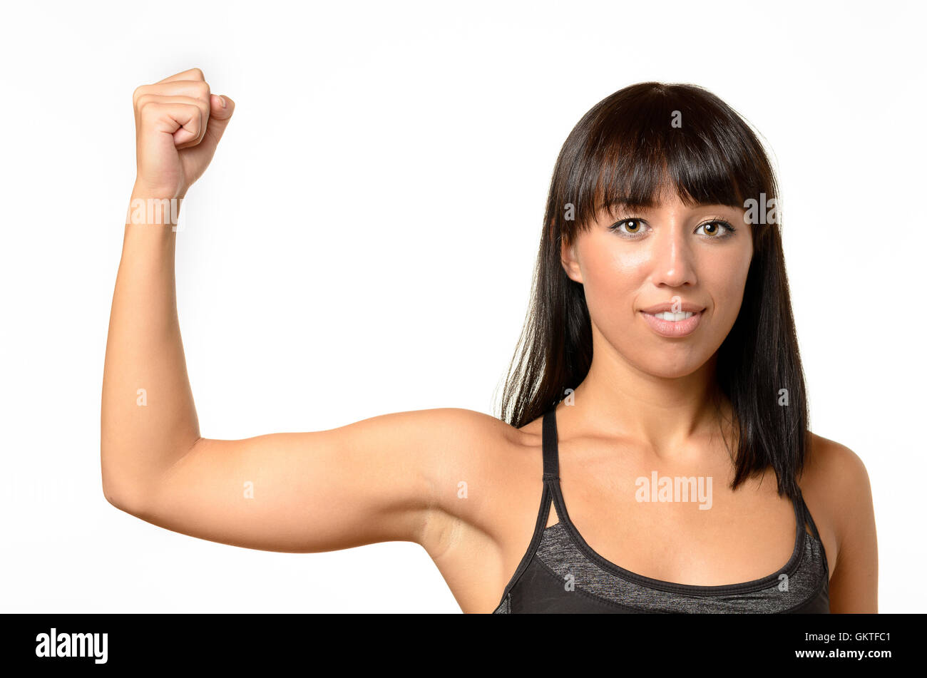Attractive friendly young woman flexing her bare arm to show her biceps ...